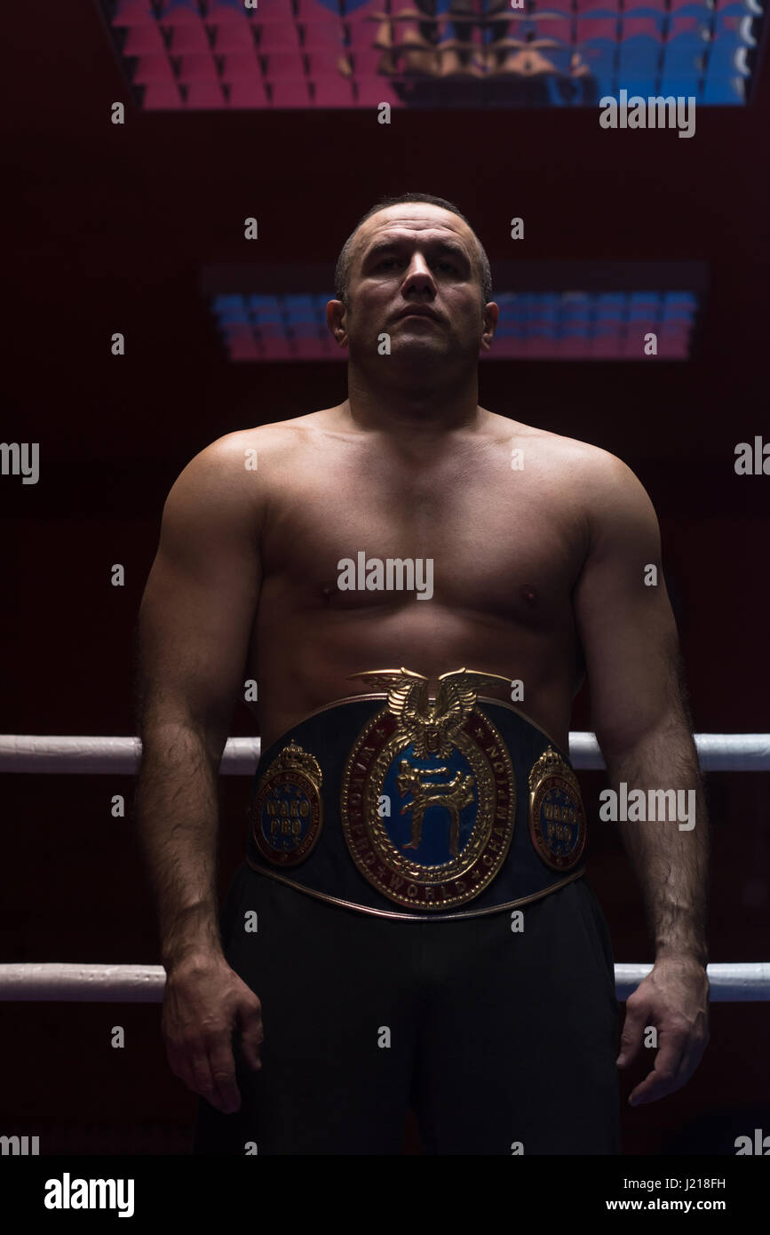 portrait of muscular professional kick boxer with his championship belt ...
