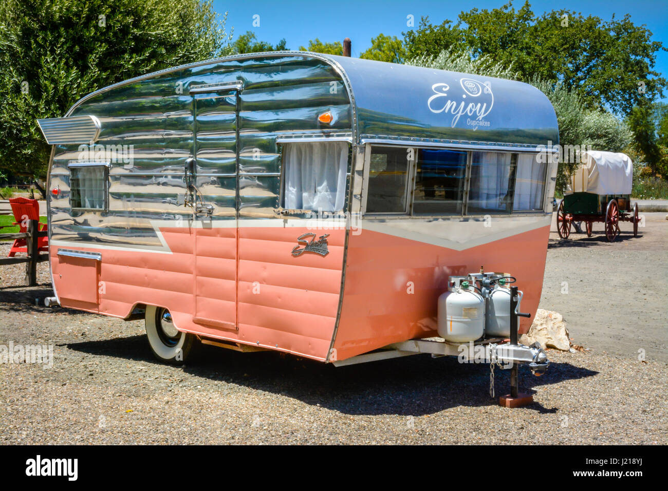 A salmon & silver colored classic, charming, vintage camper trailer in ...