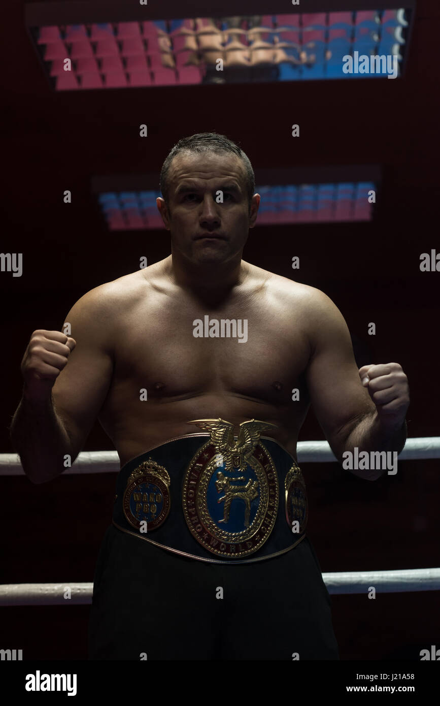 portrait of muscular professional kick boxer with his championship belt ...