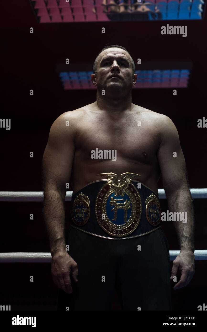 portrait of muscular professional kick boxer with his championship belt ...