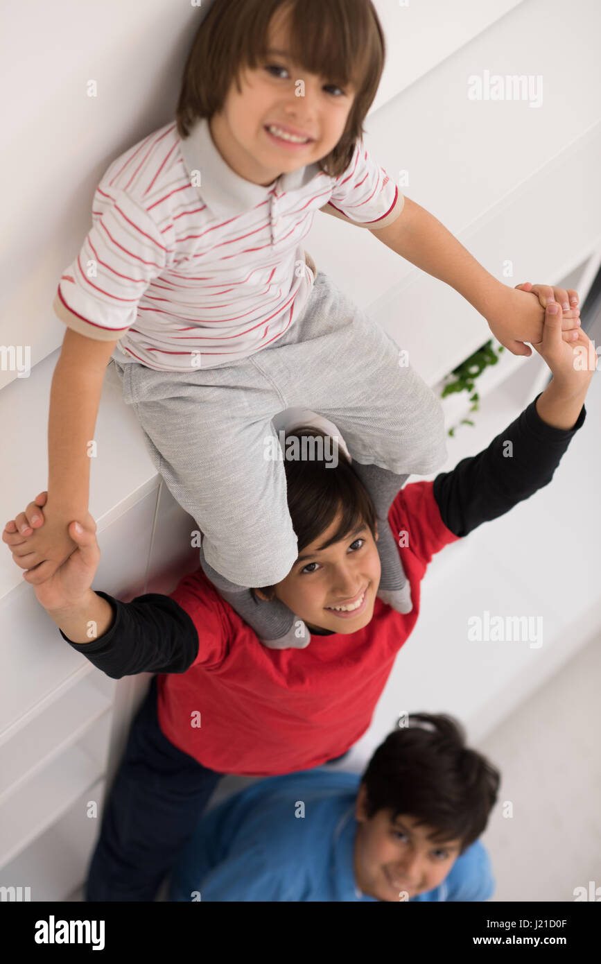 happy young boys having fun and posing line up piggyback in new modern ...
