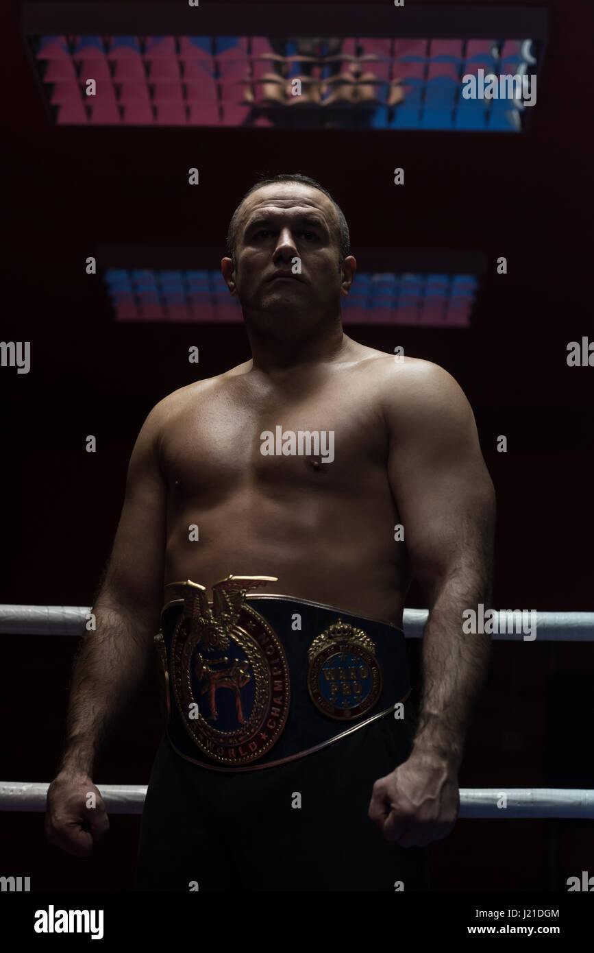 portrait of muscular professional kick boxer with his championship belt ...