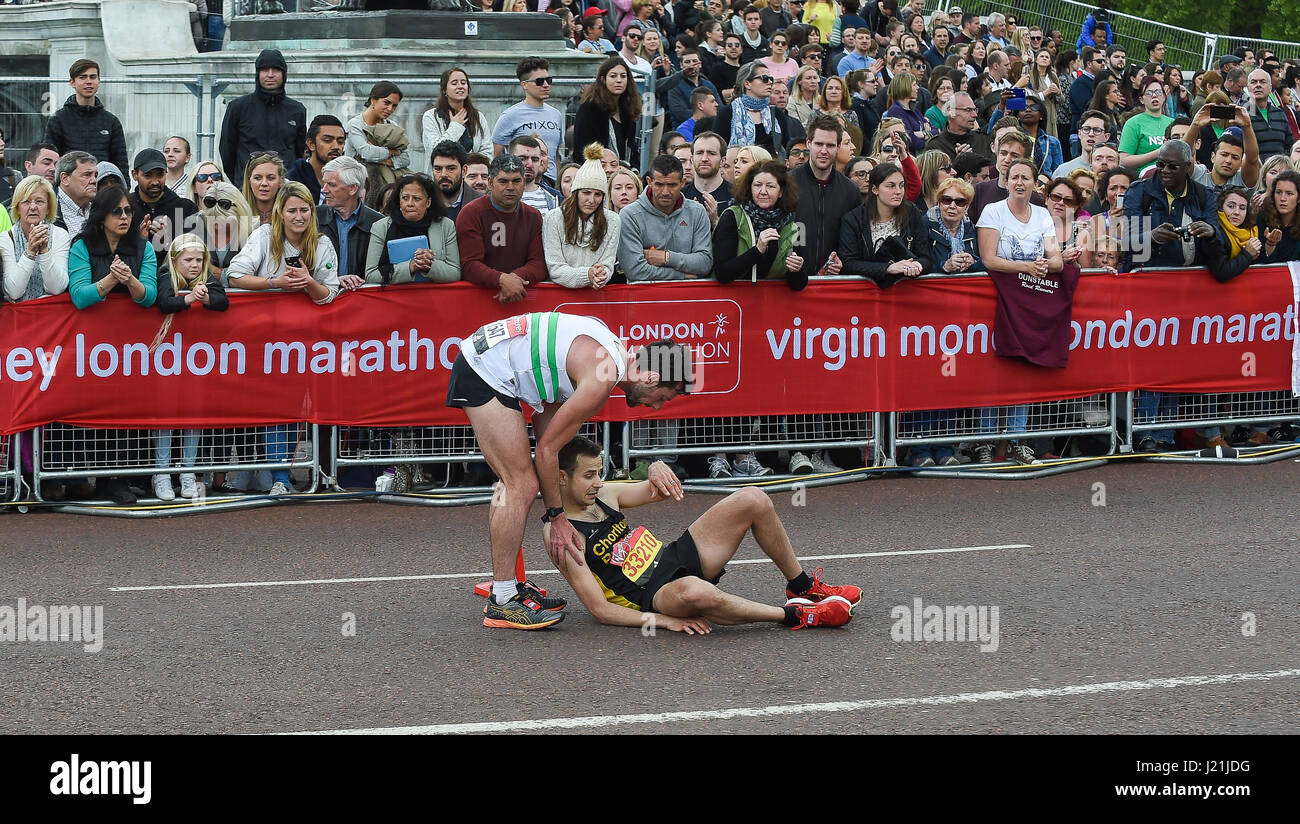 Matthew Rees of Swansea Harriers helps David Wyeth of Chorlton Harrier ...