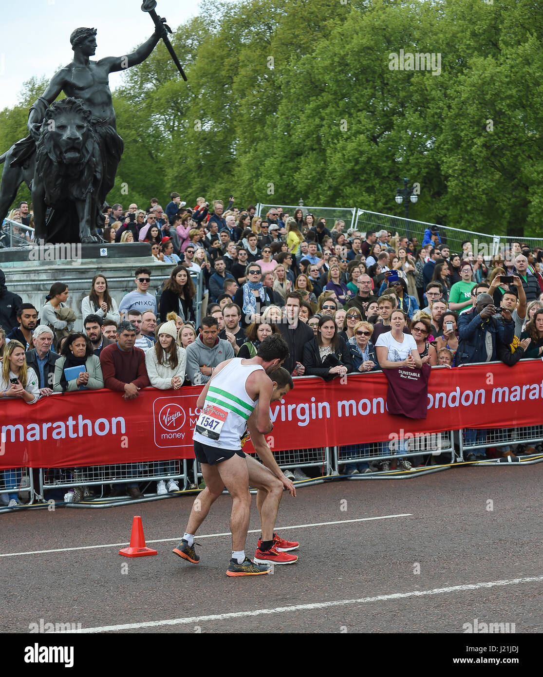 Matthew Rees of Swansea Harriers helps David Wyeth of Chorlton Harrier ...