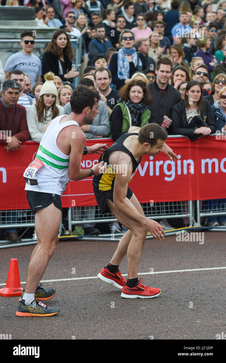 Matthew Rees of Swansea Harriers helps David Wyeth of Chorlton Harrier ...