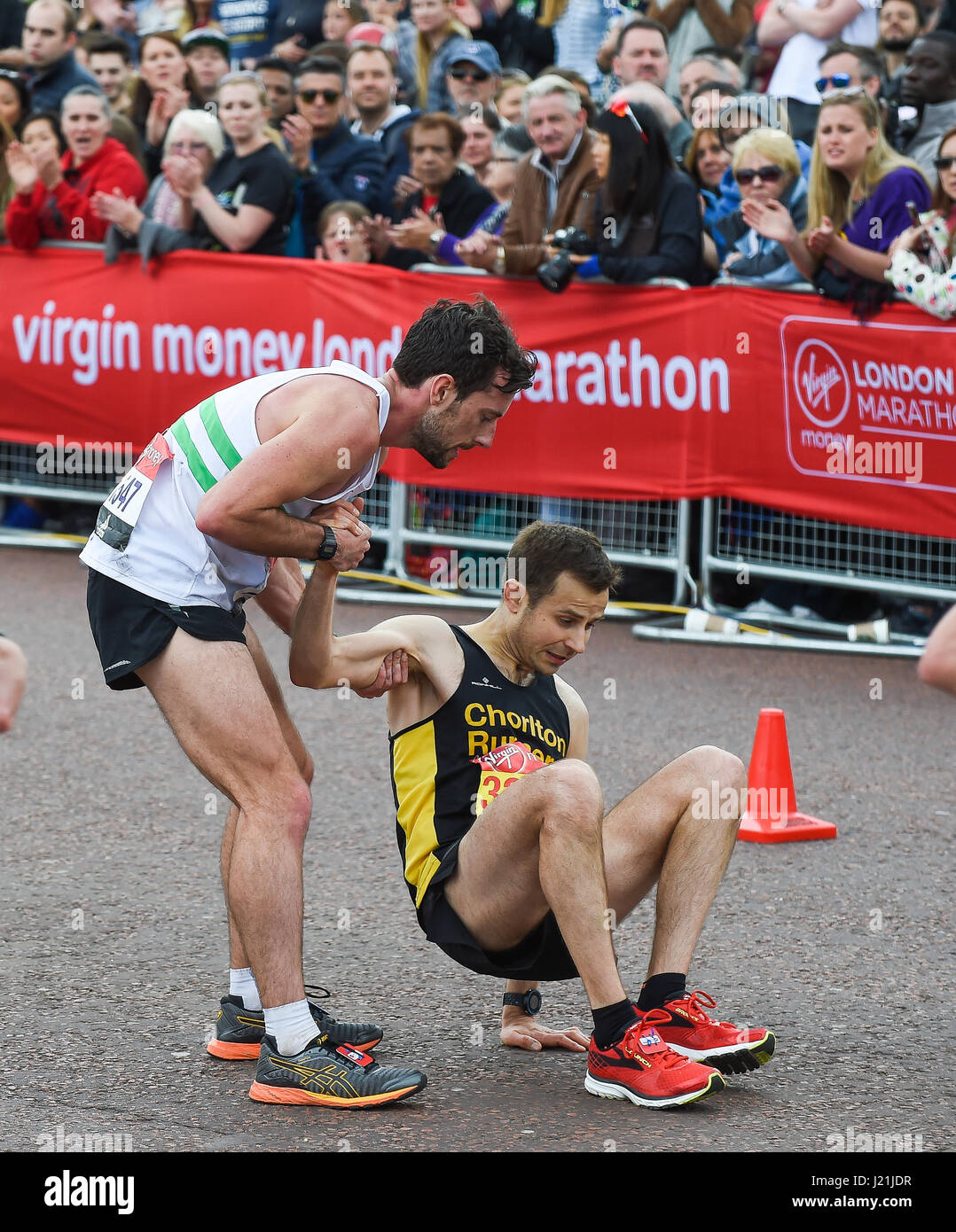 Matthew Rees of Swansea Harriers helps David Wyeth of Chorlton Harrier ...