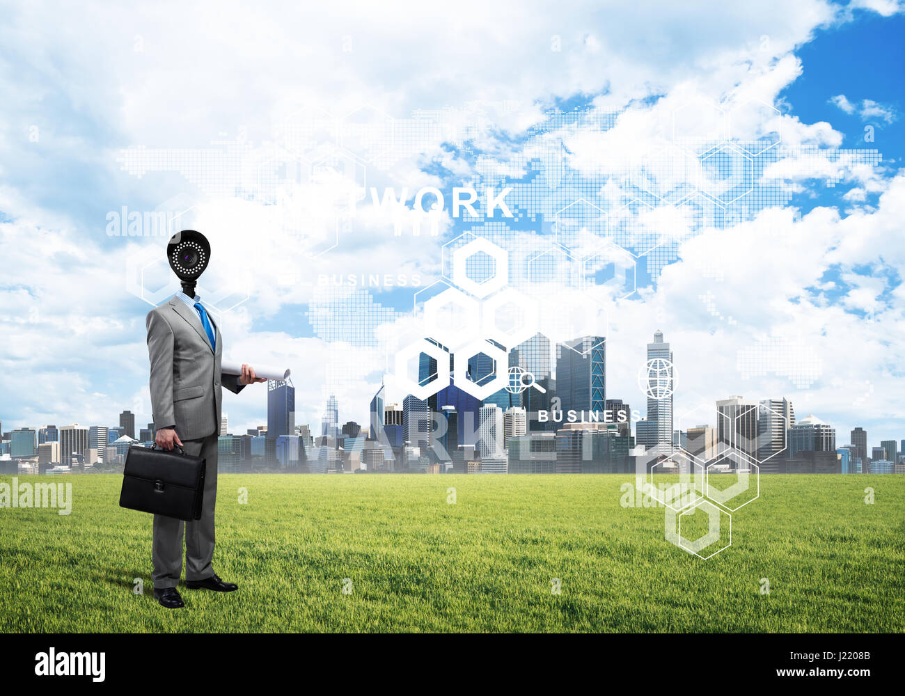 Camera headed man standing on green grass against modern cityscape ...