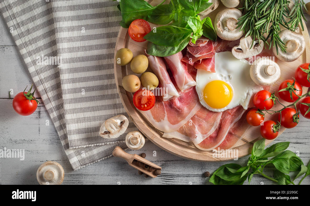 Healthy Mediterranean breakfast groceries: fried eggs, ham, vine ...