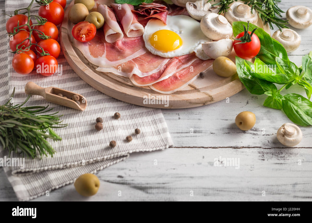 Healthy Mediterranean breakfast groceries: fried eggs, ham, vine ...
