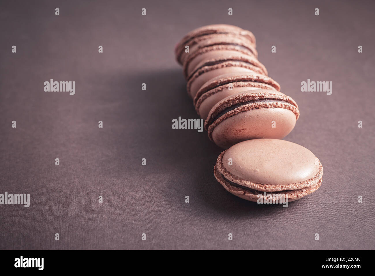 Row of Chocolate pastel brown Macarons or Macaroons over dark ...