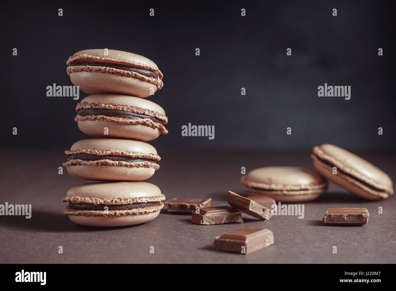 Stack of Chocolate pastel brown Macarons or Macaroons over dark ...