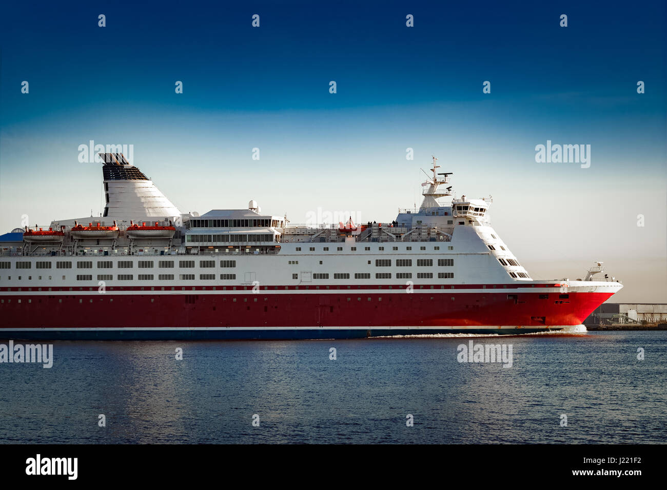 Red cruise liner. Passenger ferry ship sailing in still water Stock ...