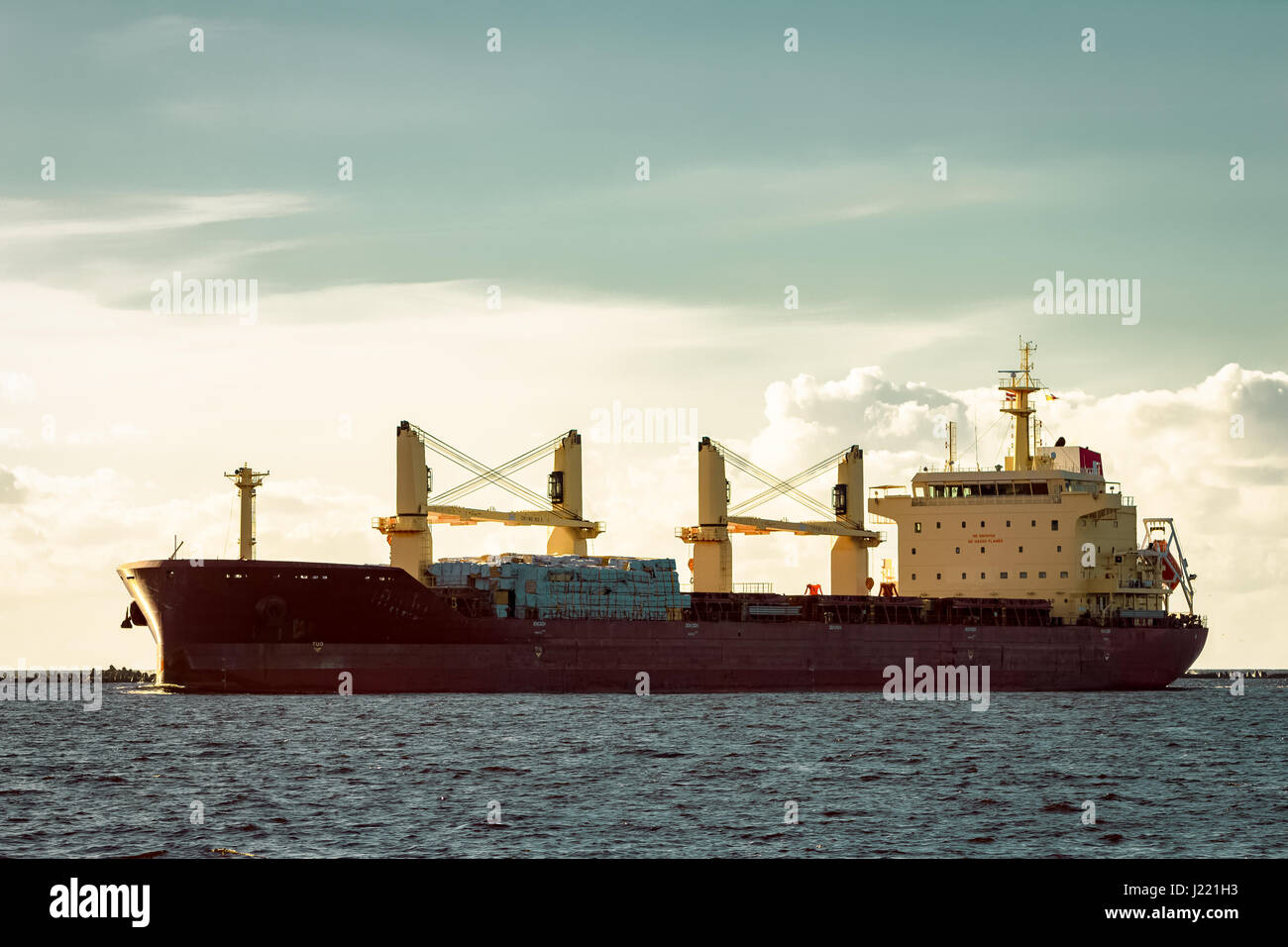 Red cargo ship moving entering the port of Riga Stock Photo - Alamy
