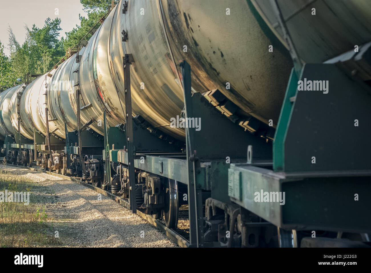 Tank wagons with oil. Freight train in forest Stock Photo - Alamy
