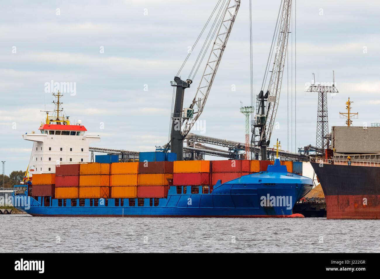 Blue container ship loading in cargo port of Europe Stock Photo - Alamy