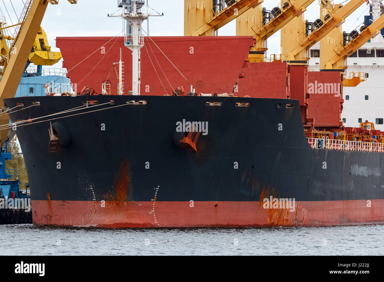 Black cargo ship loading in the port of Riga, Europe Stock Photo - Alamy