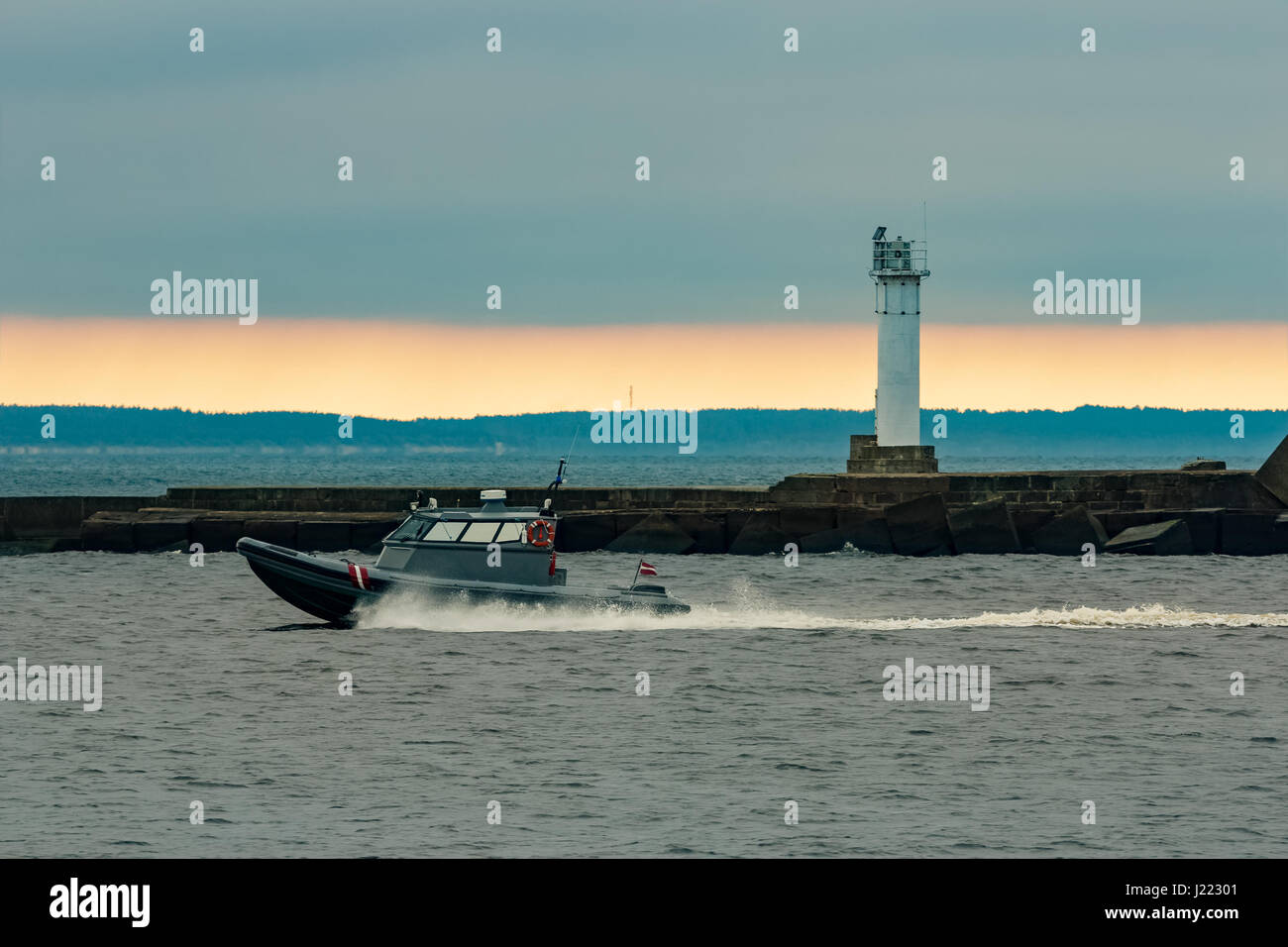 Small grey border guard boat moving fast in still evening Stock Photo ...