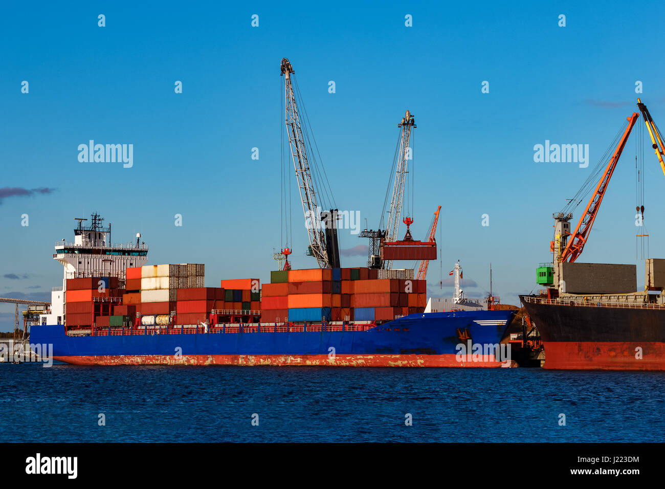 Blue container ship loading in cargo port of Europe Stock Photo - Alamy