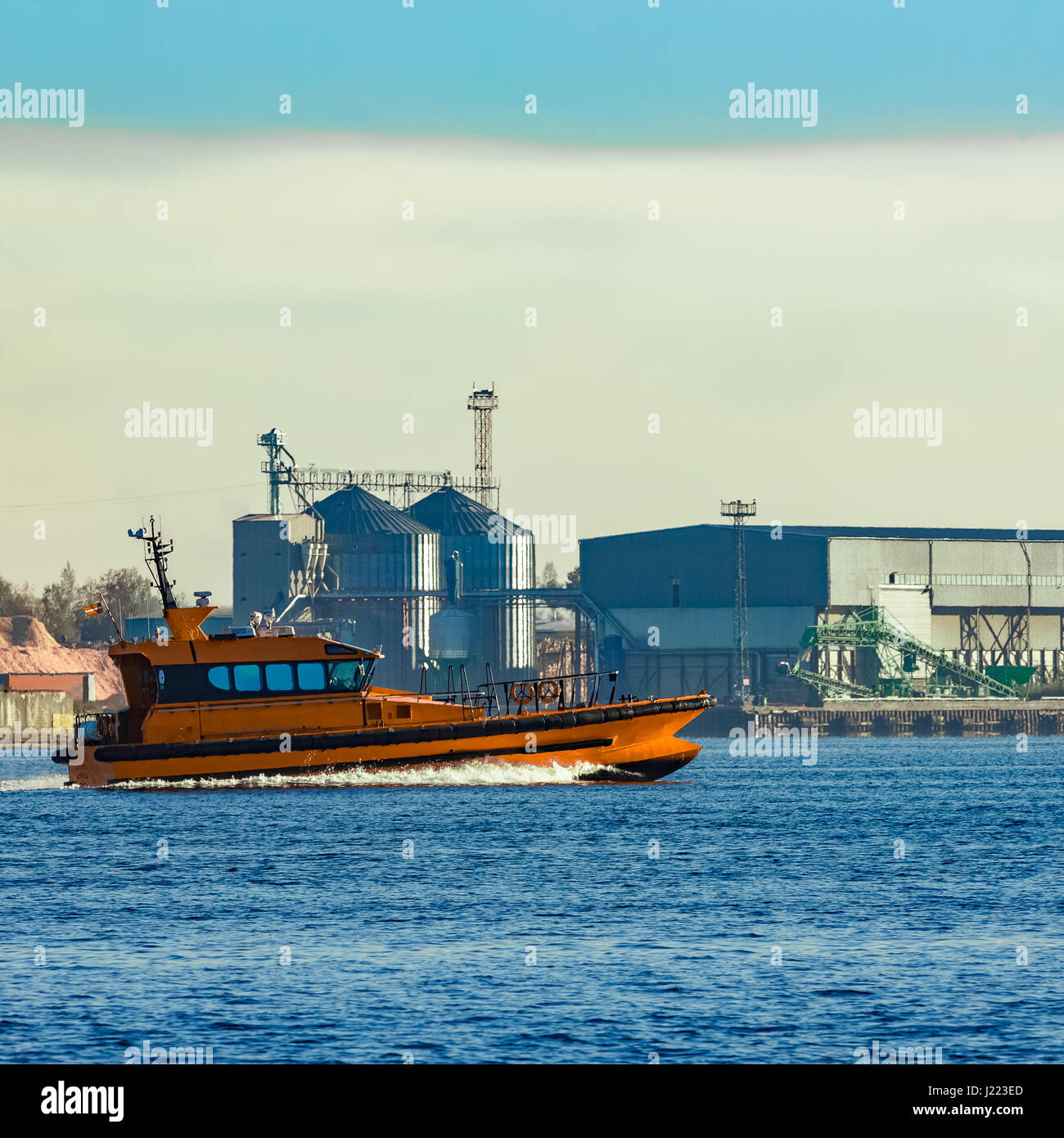 Orange pilot ship sailing past the factory in Latvia Stock Photo - Alamy