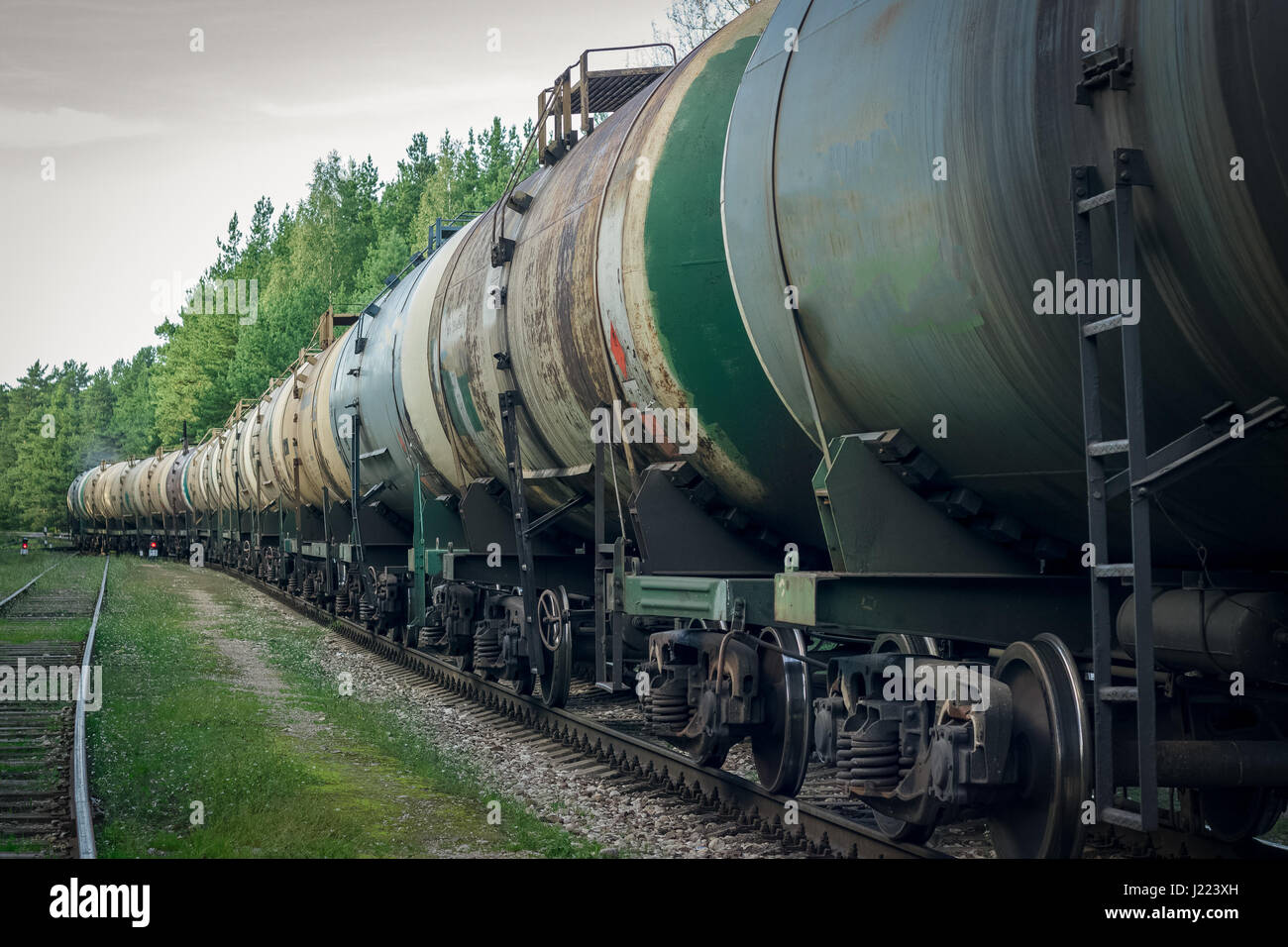 Tank wagons with oil. Freight train in forest Stock Photo - Alamy