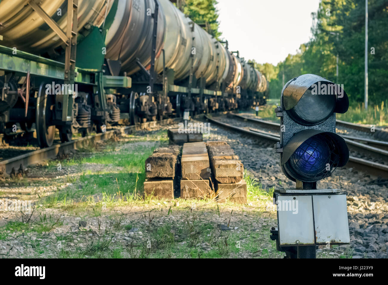 Railroad traffic light and freight train on behind Stock Photo - Alamy
