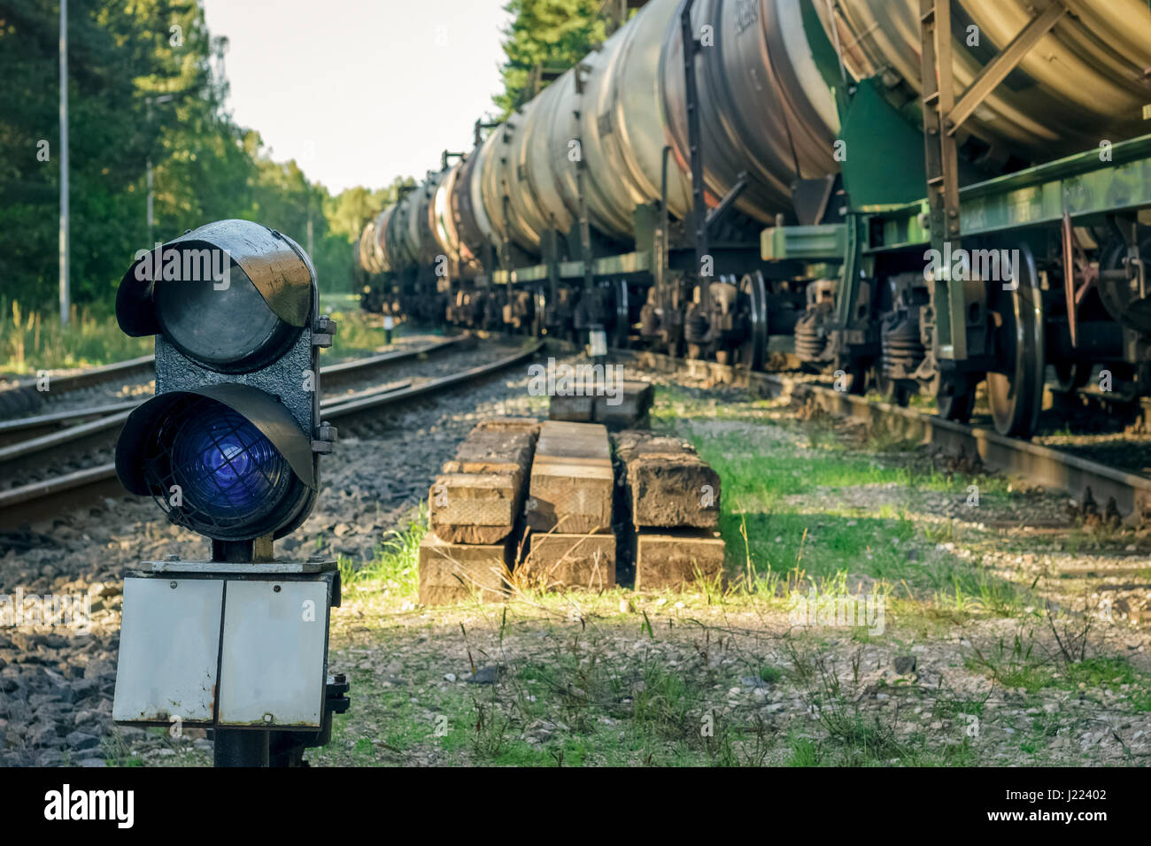 Railroad traffic light and freight train on behind Stock Photo - Alamy