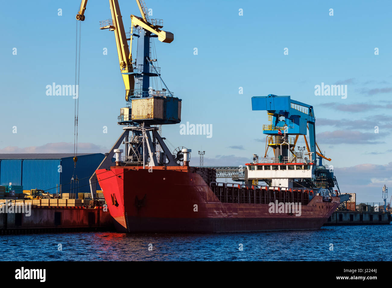 Red cargo ship loading in the port of Riga, Europe Stock Photo - Alamy