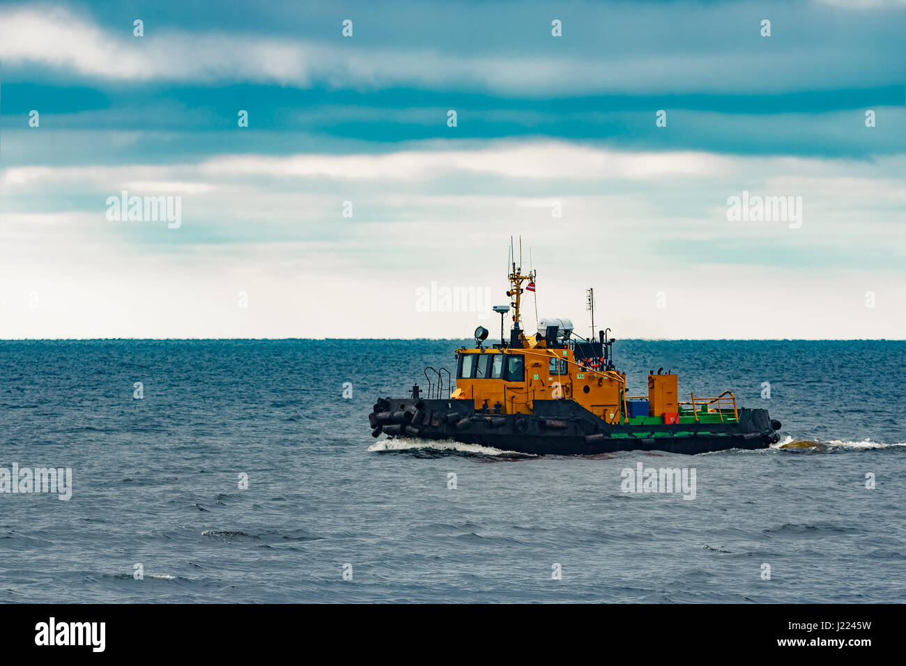 Small orange tug ship moving from the Baltic sea Stock Photo - Alamy