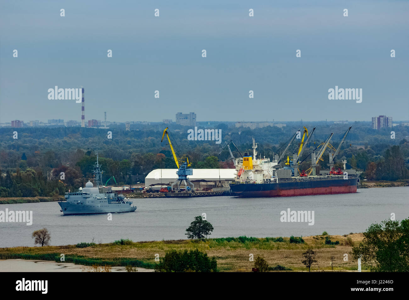 Military ship sailing past the cargo port in Riga, Latvia Stock Photo ...