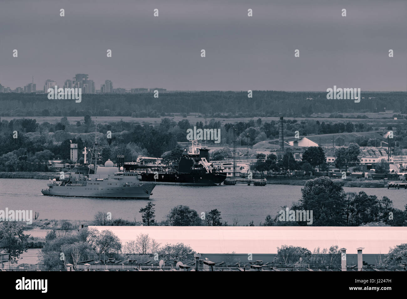 Military ship sailing past the cargo port in Riga, Latvia Stock Photo ...