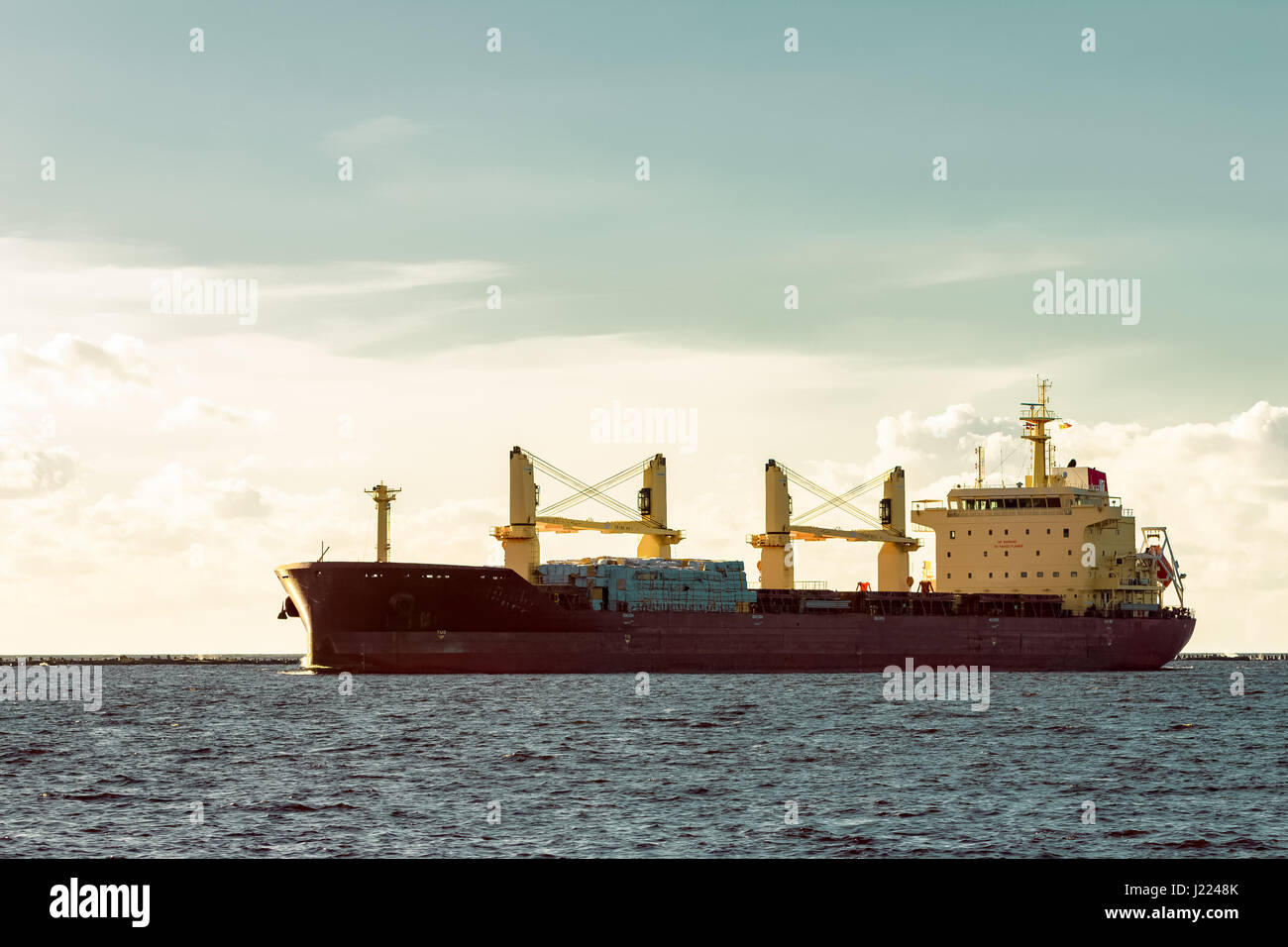 Red cargo ship moving entering the port of Riga Stock Photo - Alamy