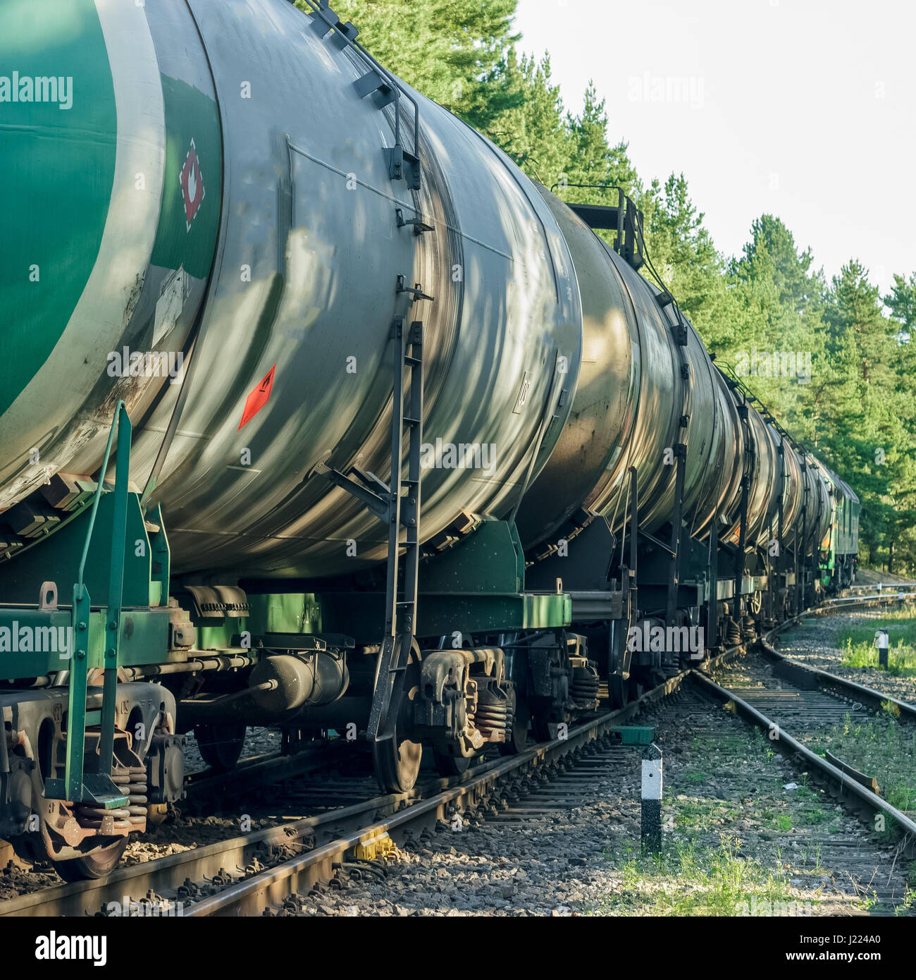 Tank wagons with oil. Freight train in forest Stock Photo - Alamy