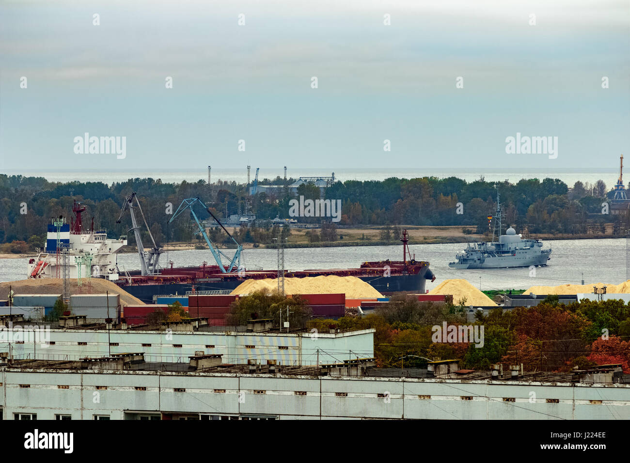 Military ship sailing past the cargo port in Riga, Latvia Stock Photo ...