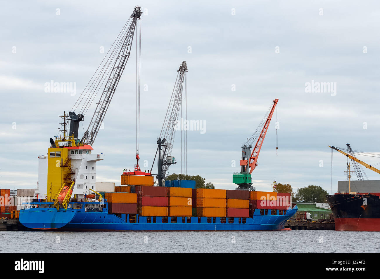 Blue container ship loading in cargo port of Europe Stock Photo - Alamy