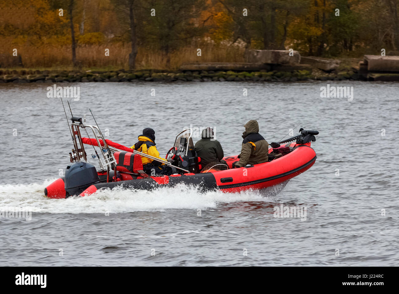 Red inflatable boat with fishermans moving at speed Stock Photo - Alamy