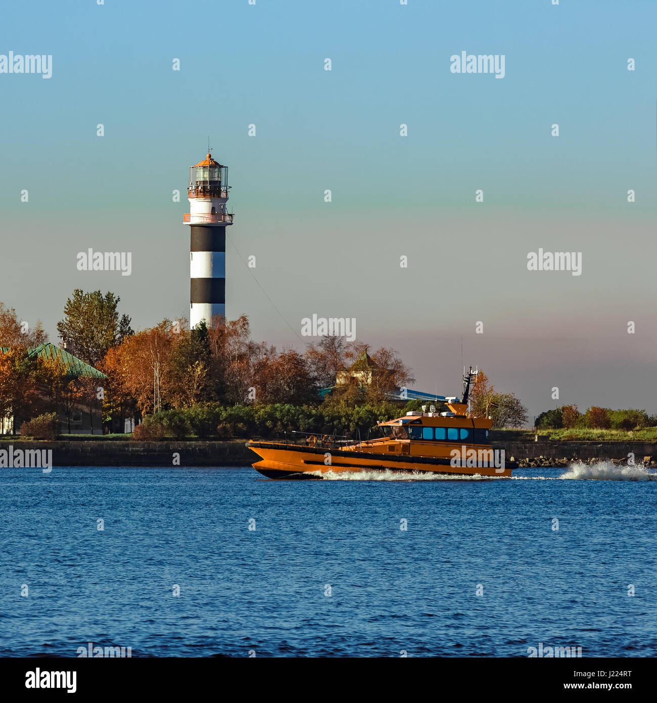 Orange pilot ship sailing past the lighthouse in Europe Stock Photo - Alamy