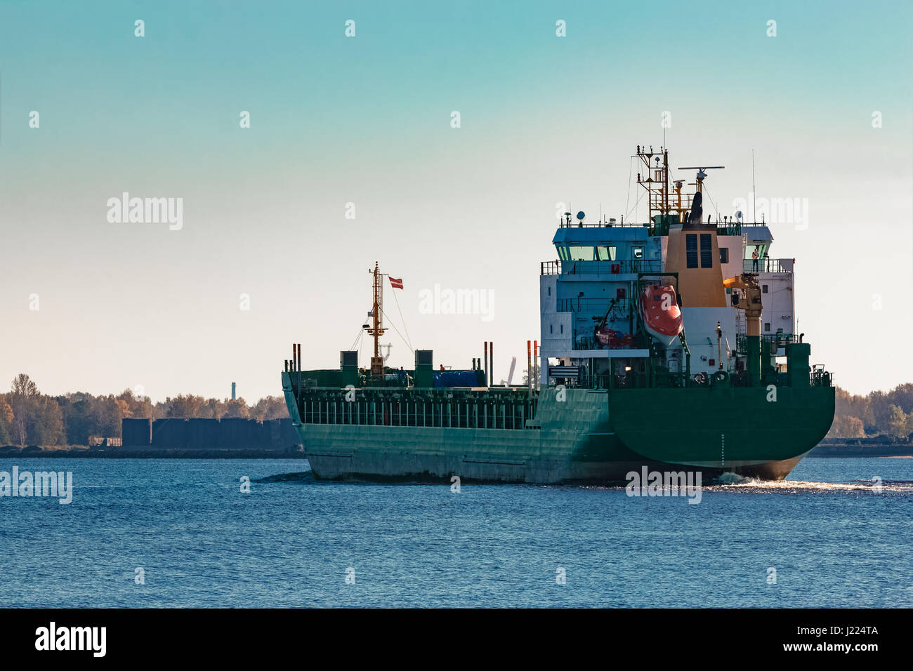 Green cargo ship entering a port of Riga, Europe Stock Photo - Alamy