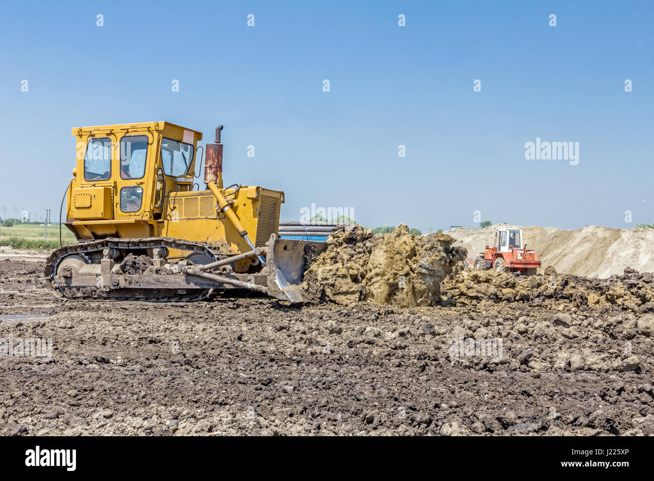 View on heavy bulldozer while he moving, leveling ground at ...