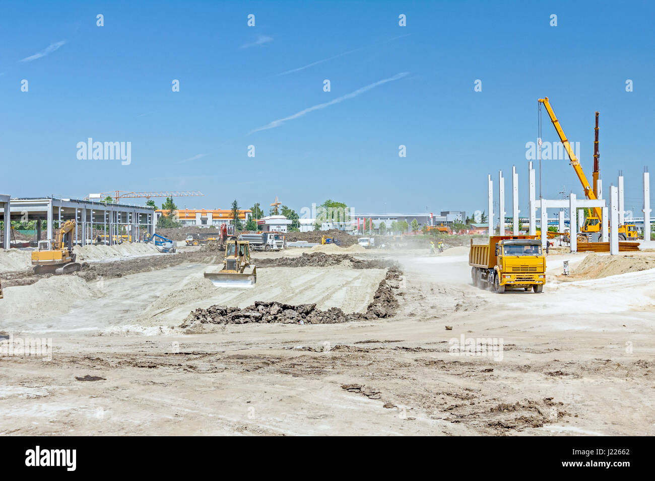 Heavy earthmover construction machine is leveling sand at building site ...