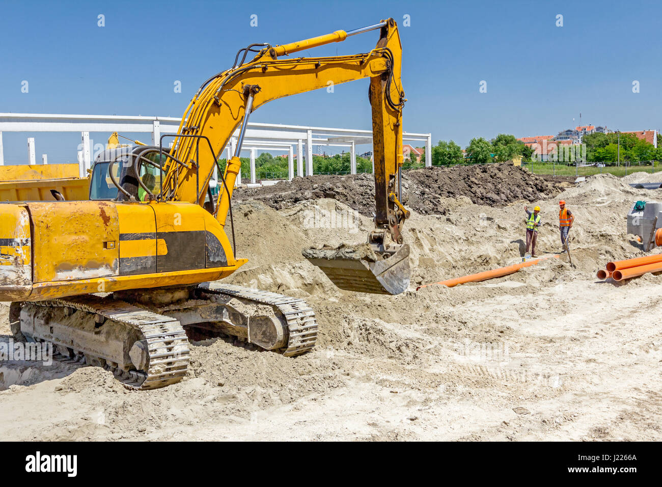 Big excavator is excavating soil at construction site, project in ...