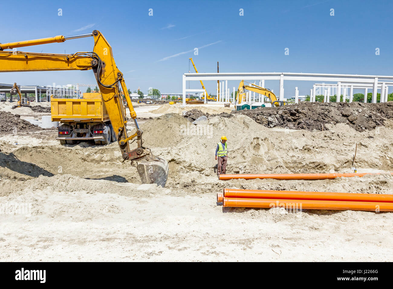 Big excavator is excavating soil at construction site, project in ...