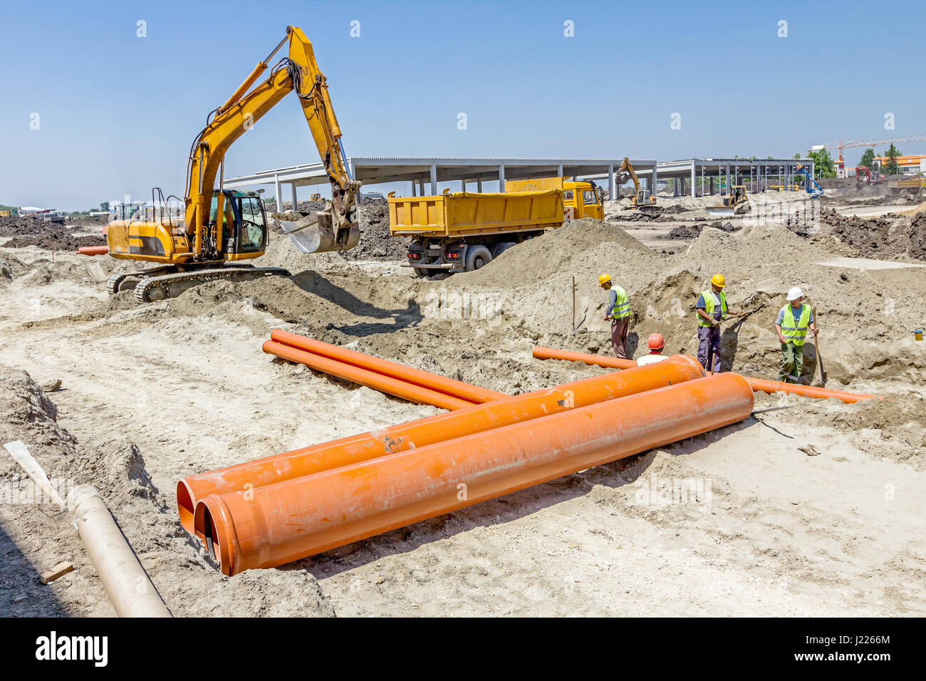 Embed water pipes in trench on building site. Big excavator is ...