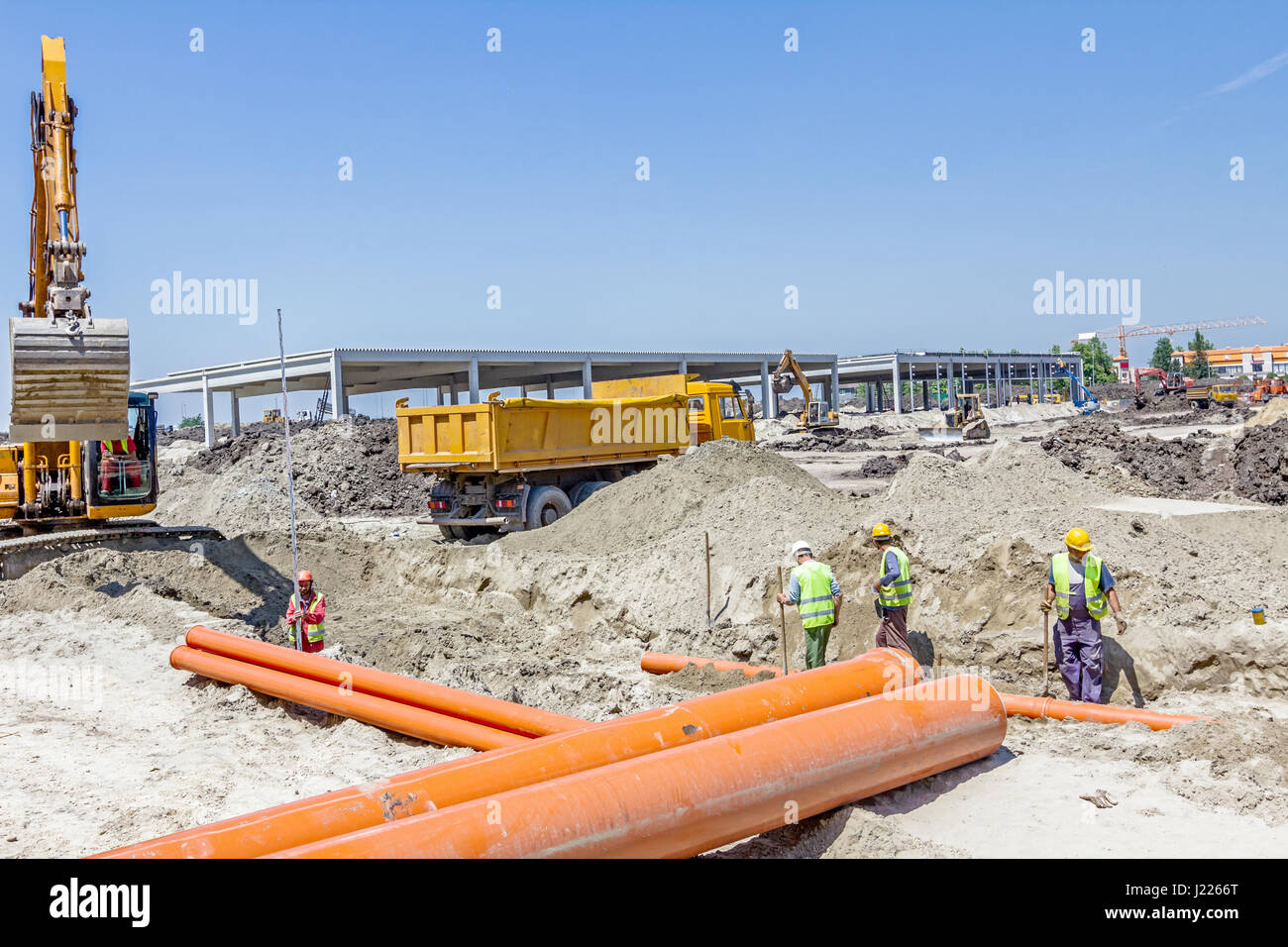 Embed water pipes in trench on building site. Big excavator is ...