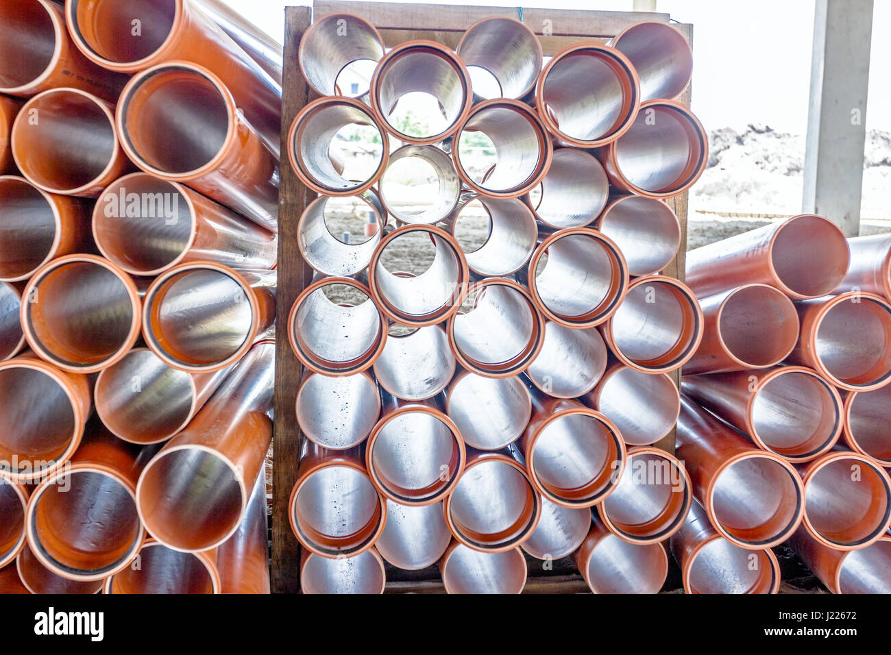 Sewer pipes waiting to be placed into the ditch at construction site ...