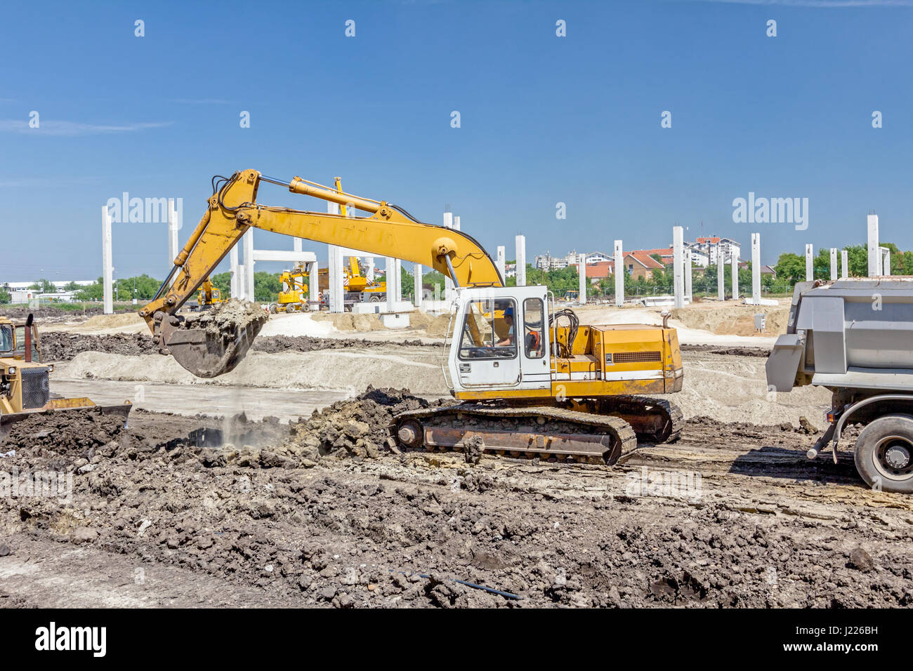 Big excavator is excavating soil at construction site, project in ...