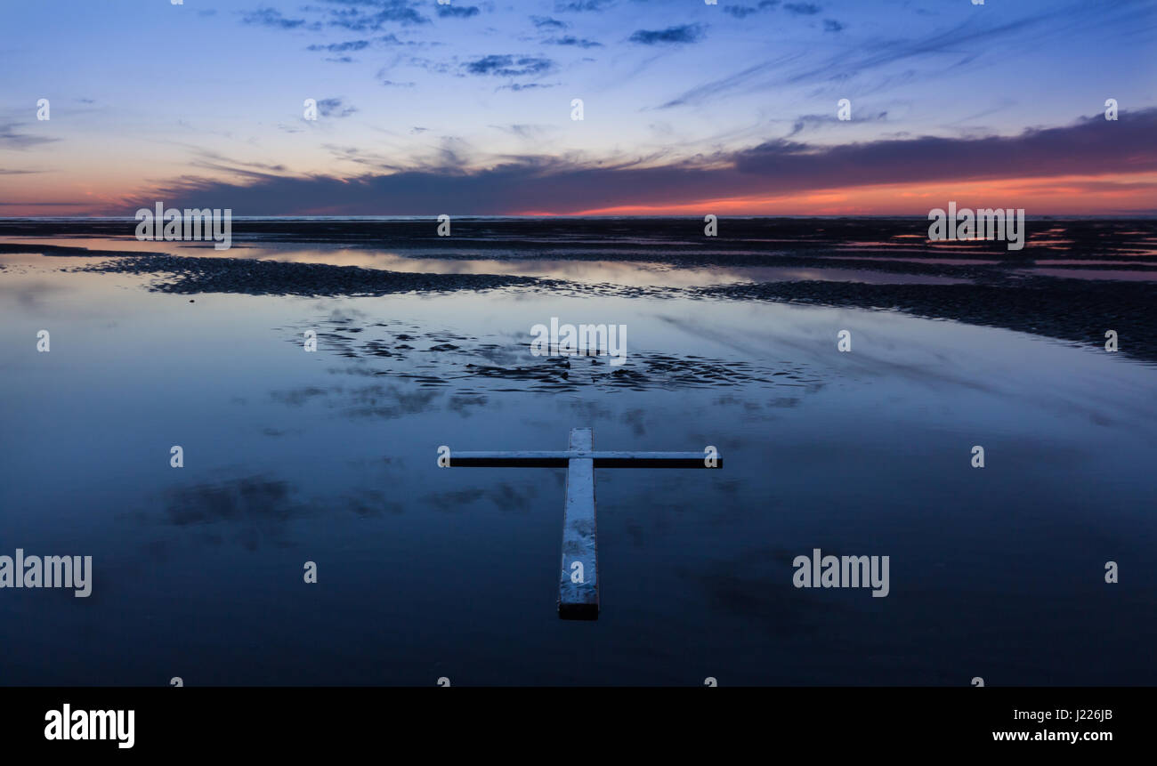 Floating cross on low tide waters at sundown Stock Photo - Alamy