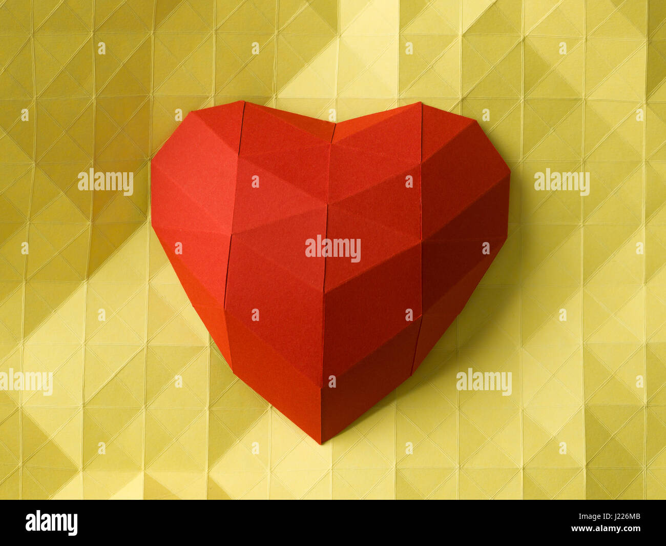 papercraft heart on yellow background poly Stock Photo - Alamy