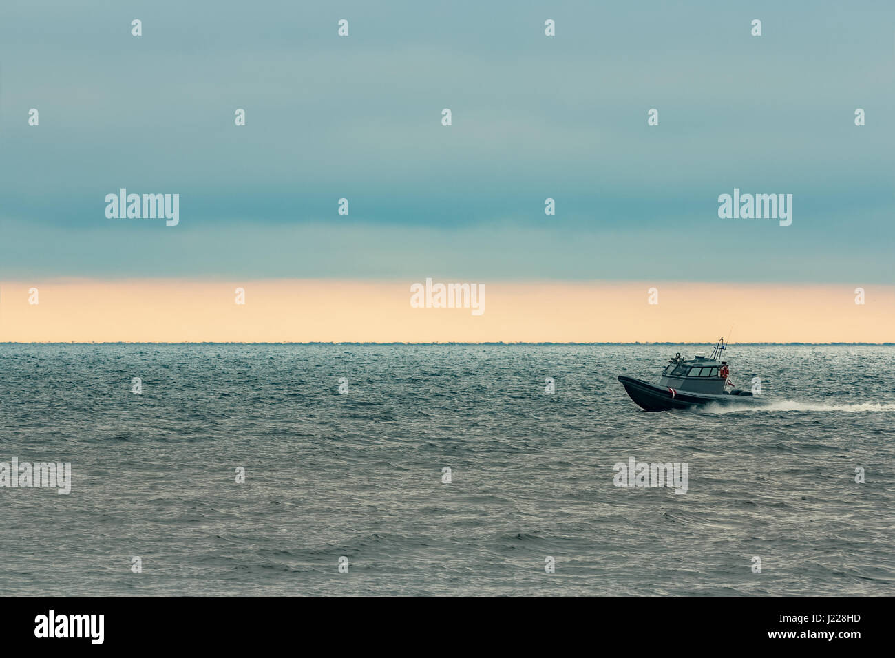 Small grey border guard boat moving fast in still evening Stock Photo ...
