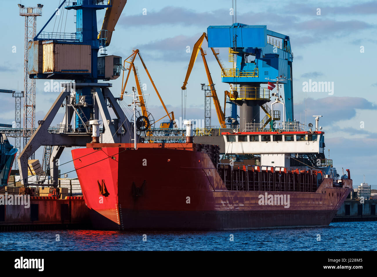 Red cargo ship loading in the port of Riga, Europe Stock Photo - Alamy