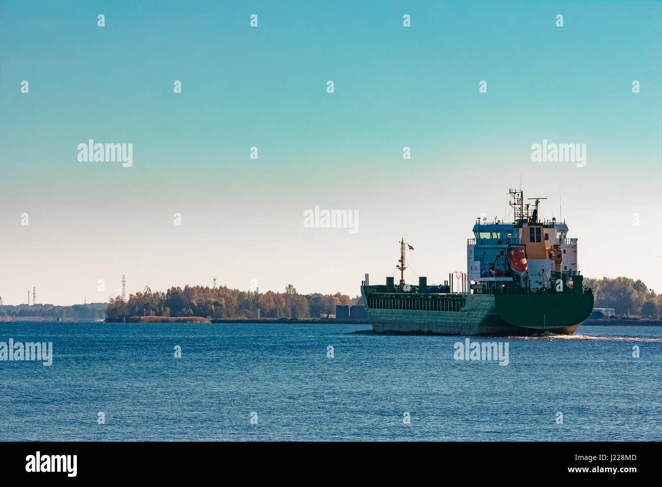 Green cargo ship entering a port of Riga, Europe Stock Photo - Alamy